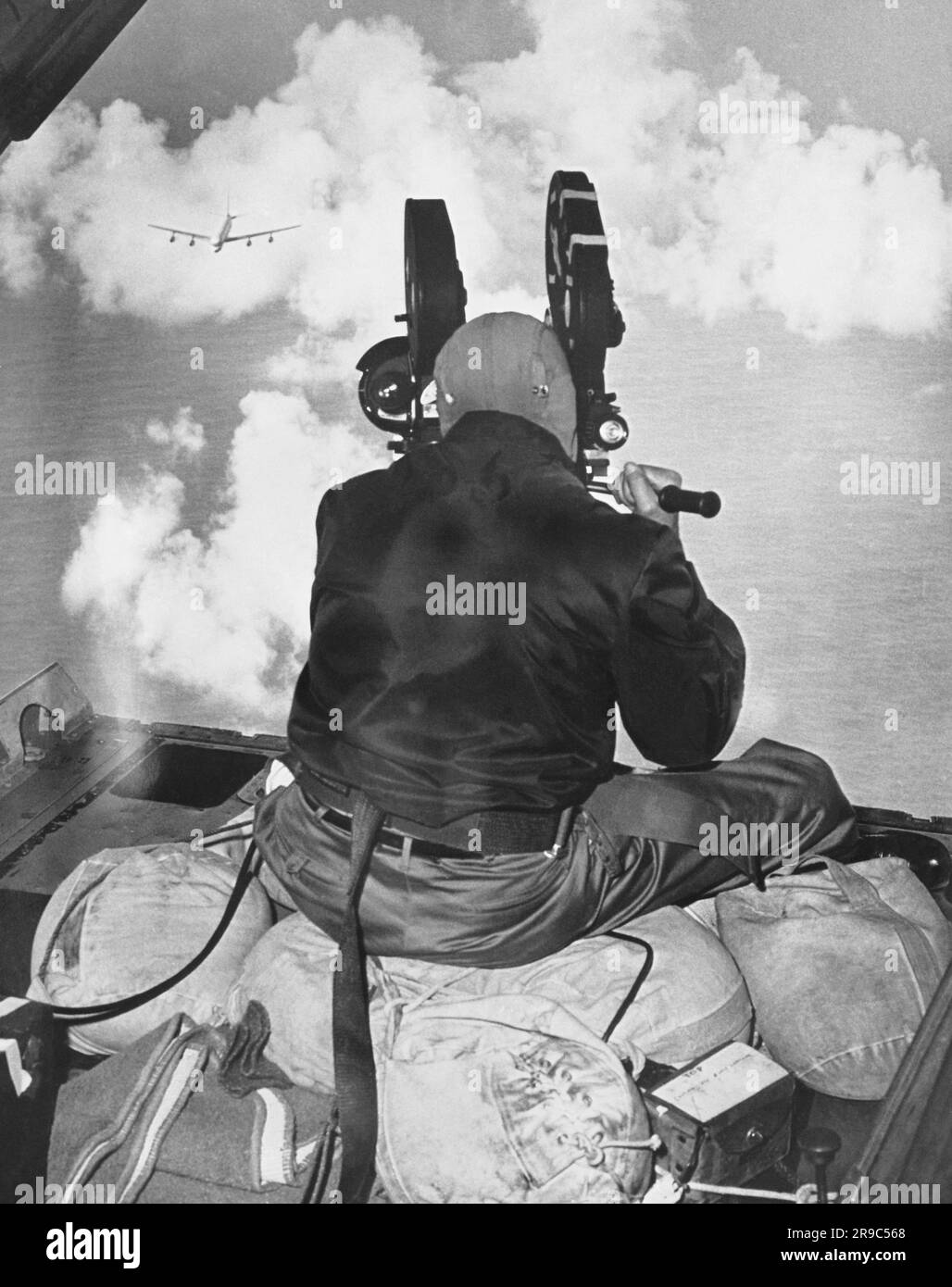 United States: c. 1955 A newsreel photographer filming a jet plane from ...