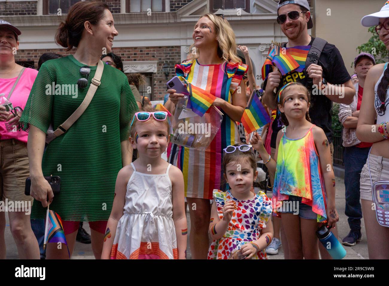 NEW YORK, NEW YORK - JUNE 25: Spectators with pride flags watch the ...