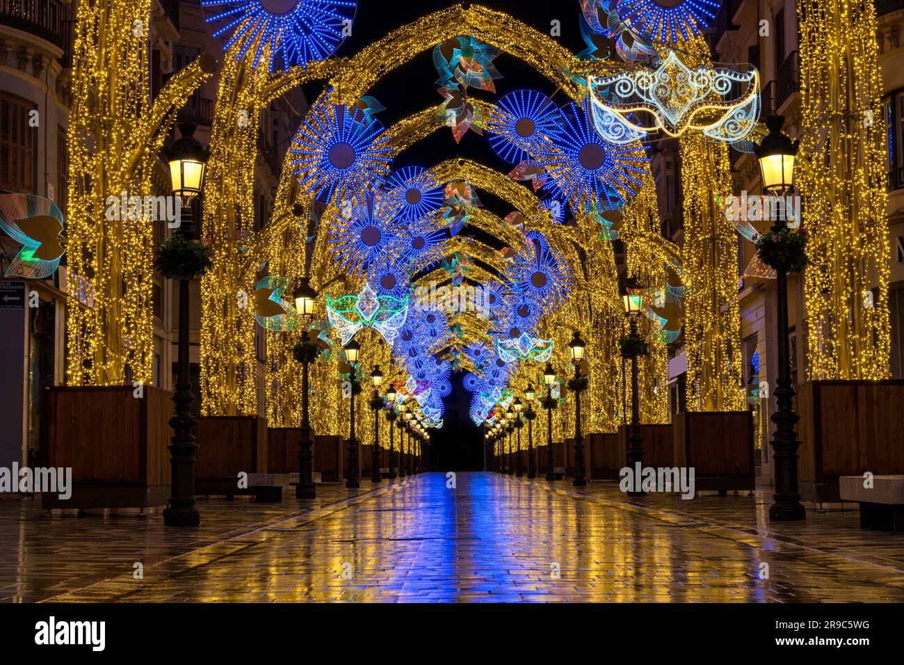 Carnival with decorative Christmas lights in Spain. The lights reflect ...