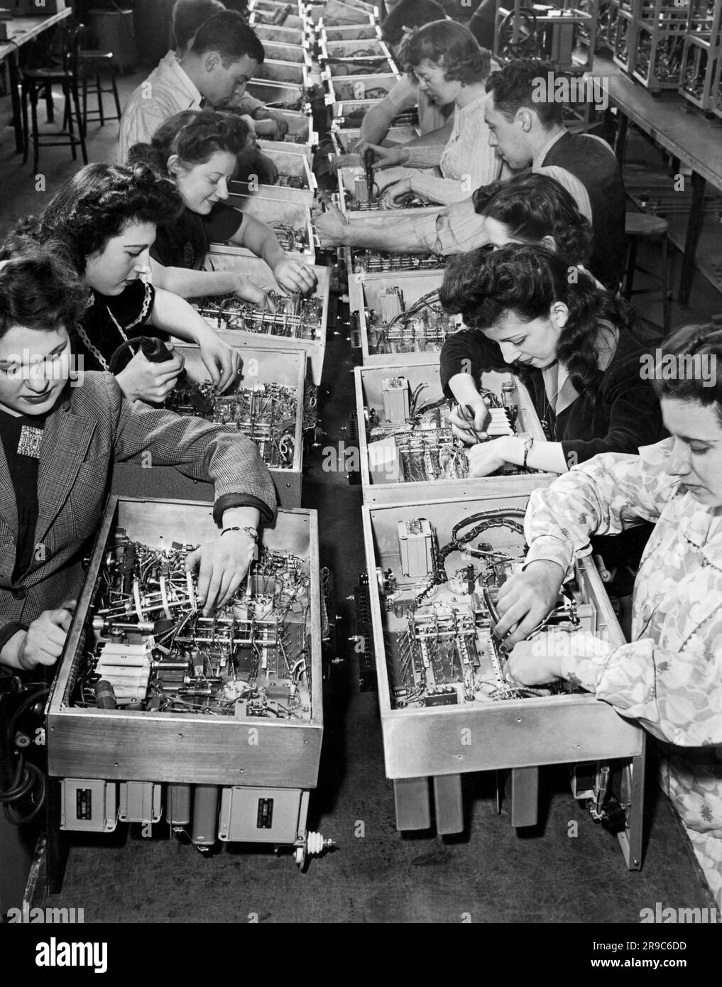 United States: c. 1940 Workers in a factory wiring radio telephone sets ...