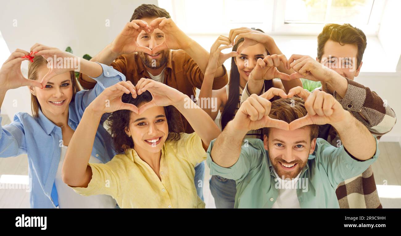 Group of happy young people making hearts with their hands as symbol of ...