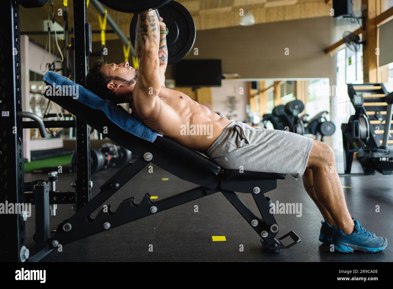 Profile of a strong man lifting weights in a gym Stock Photo - Alamy