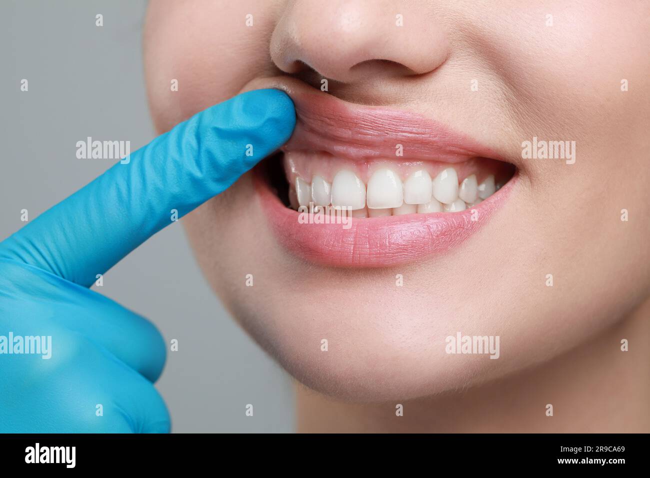 Doctor examining woman's gums on grey background, closeup Stock Photo ...