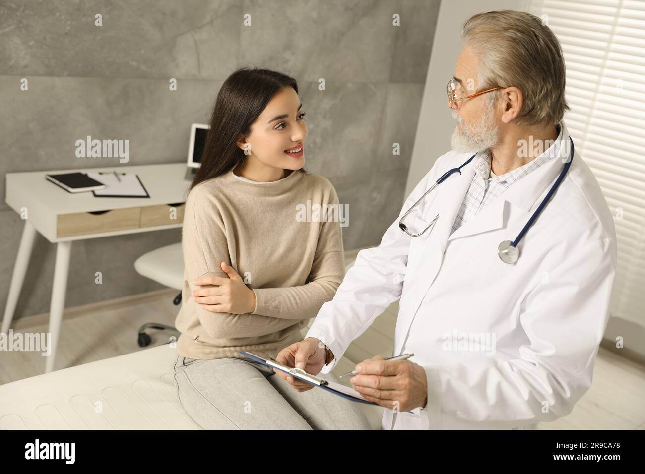 Patient having appointment with senior doctor in clinic Stock Photo - Alamy