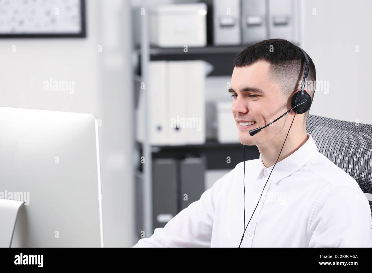 Hotline operator with headset working in office Stock Photo - Alamy