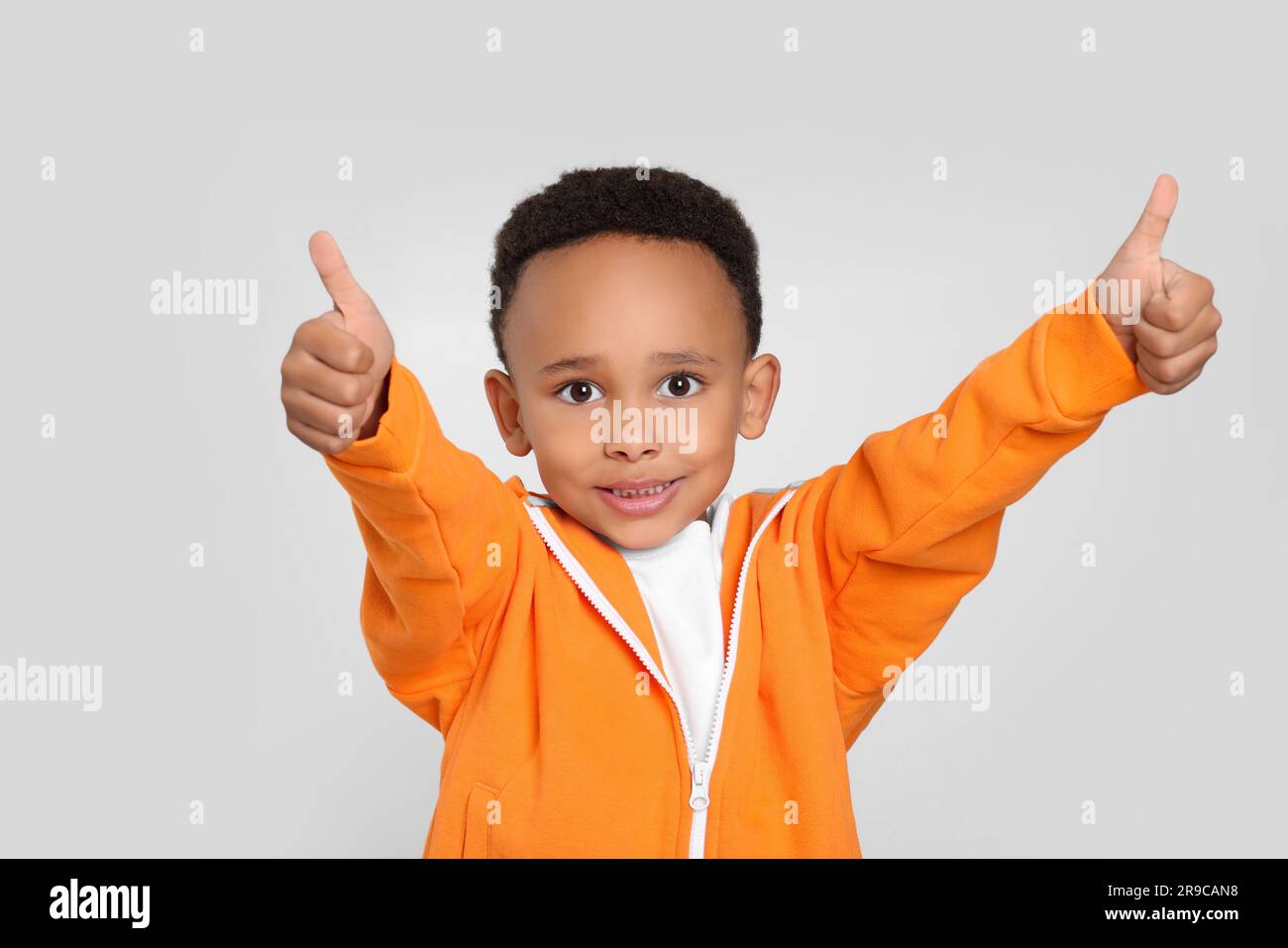 African-American boy showing thumbs up on light grey background Stock ...