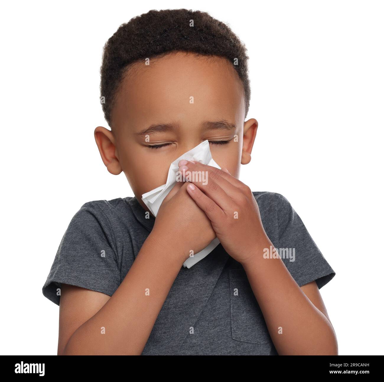 African-American boy blowing nose in tissue on white background. Cold ...