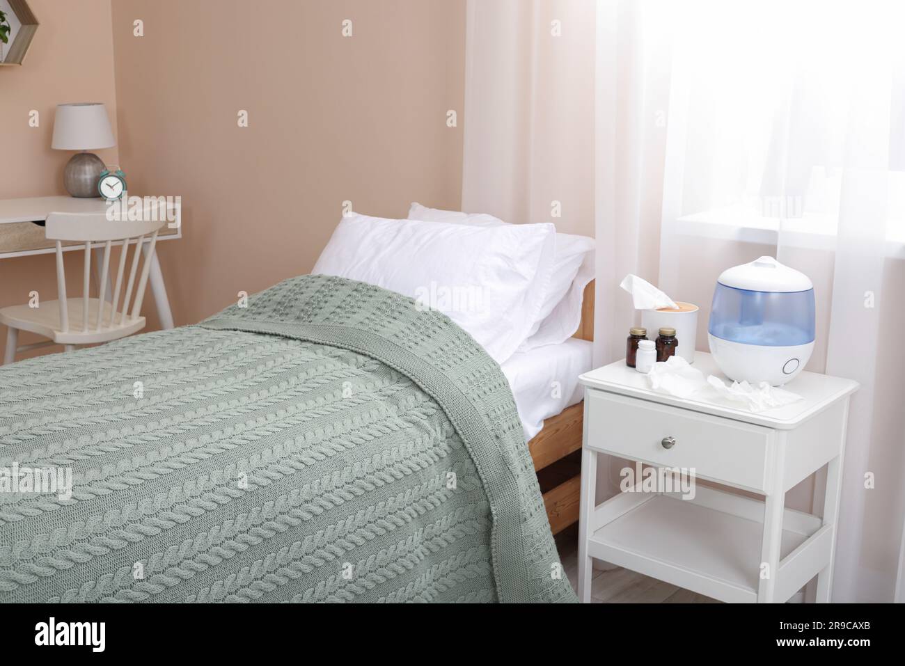 Stylish room interior with bed, table and air humidifier Stock Photo ...