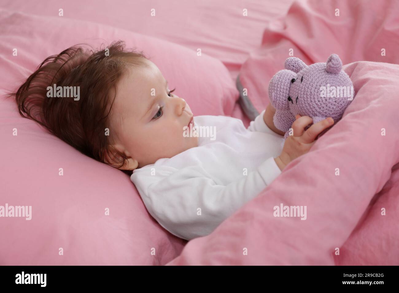 Cute little baby with toy on bed Stock Photo - Alamy