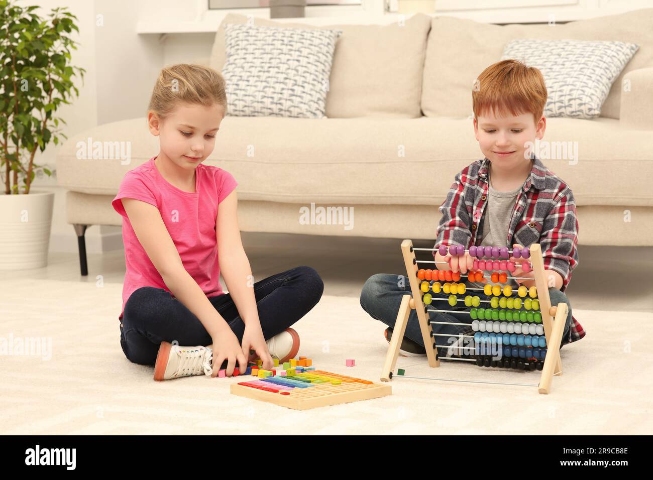 Children playing with different math game kits on floor in living room ...