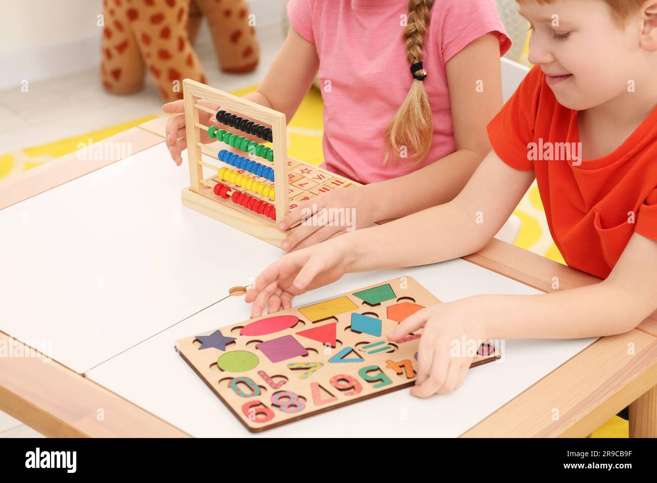 Children playing with different math game kits at desk indoors, closeup ...