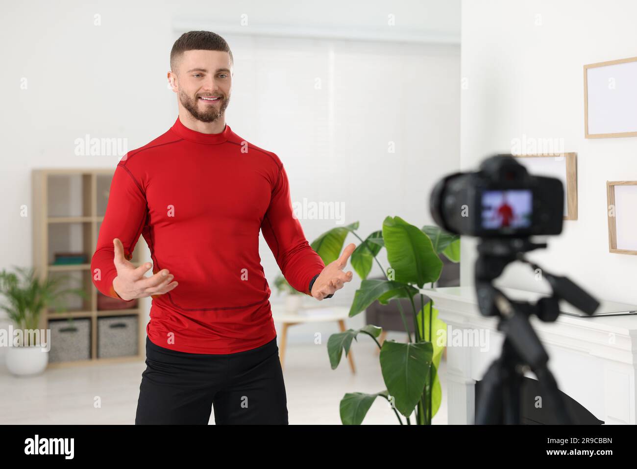 Trainer recording fitness lesson on camera at home Stock Photo - Alamy