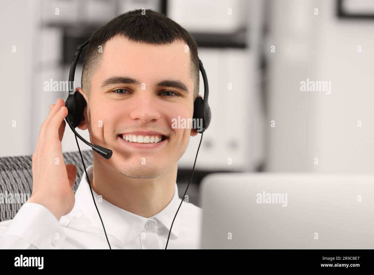 Hotline operator with headset working in office, space for text Stock ...