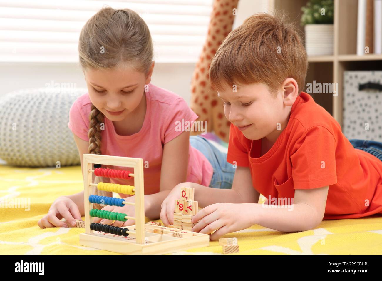 Children playing with math game kit on floor in room. Learning ...