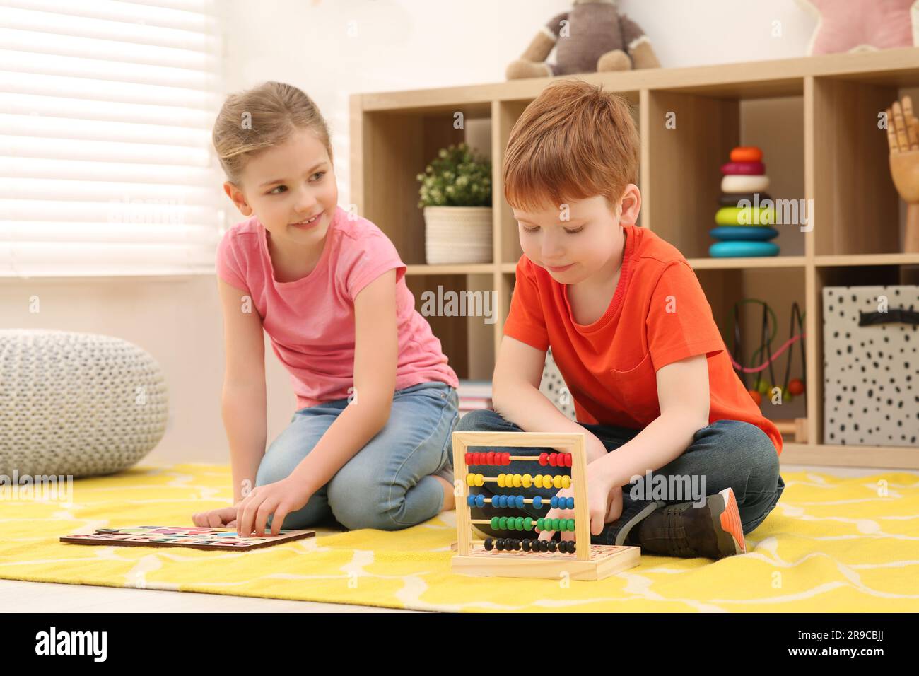 Children playing with math game kits on floor in room. Learning ...