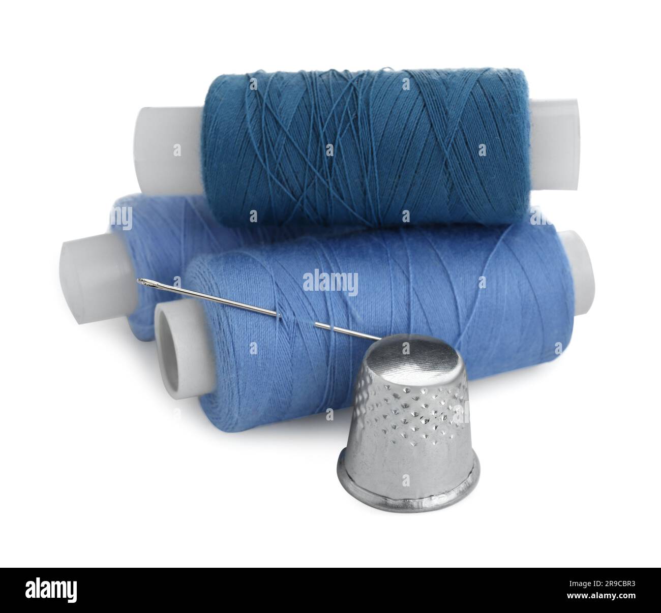 Thimble, spools of sewing threads and needle isolated on white Stock ...