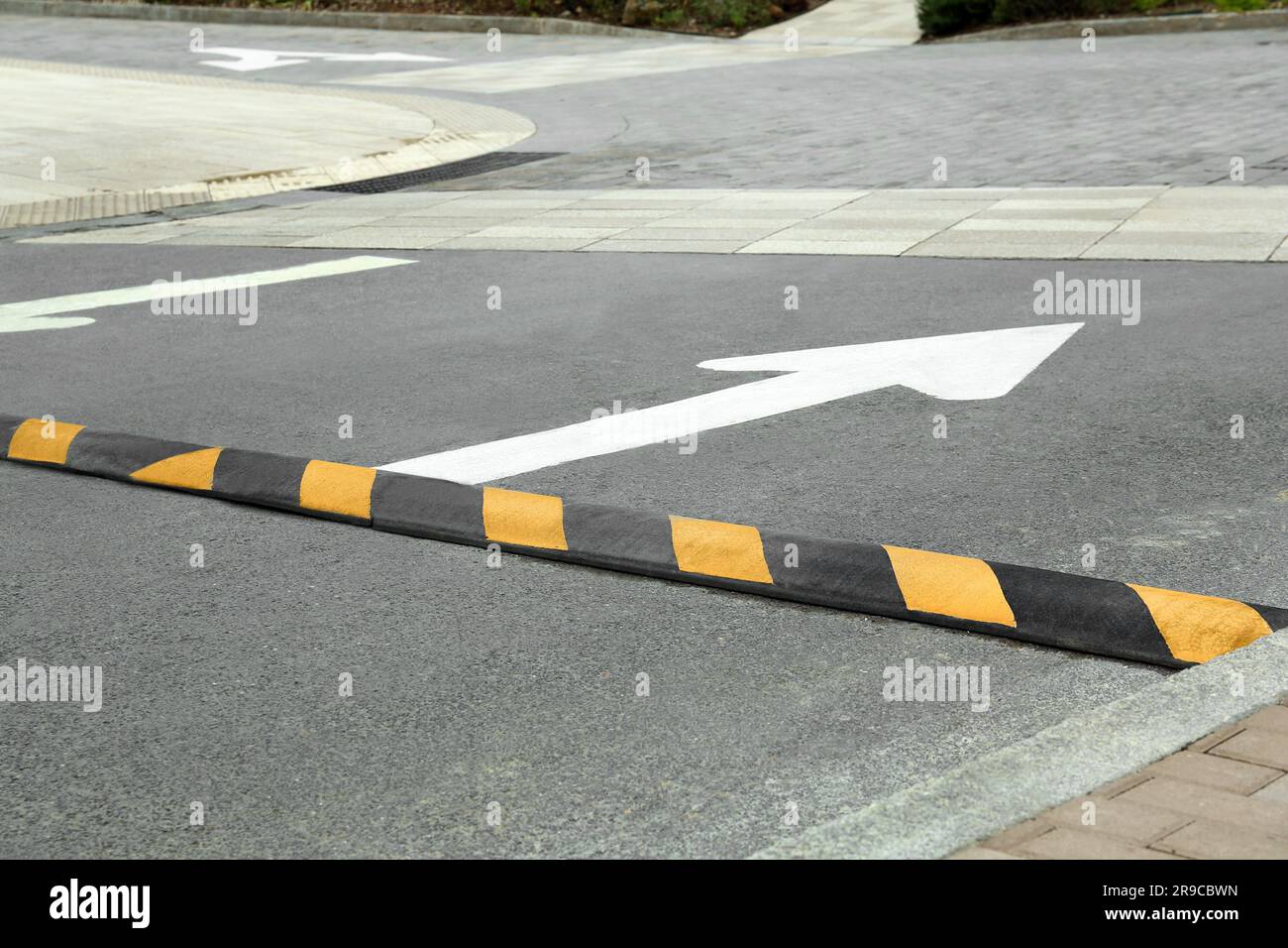 Striped speed bump on street. Road safety Stock Photo - Alamy