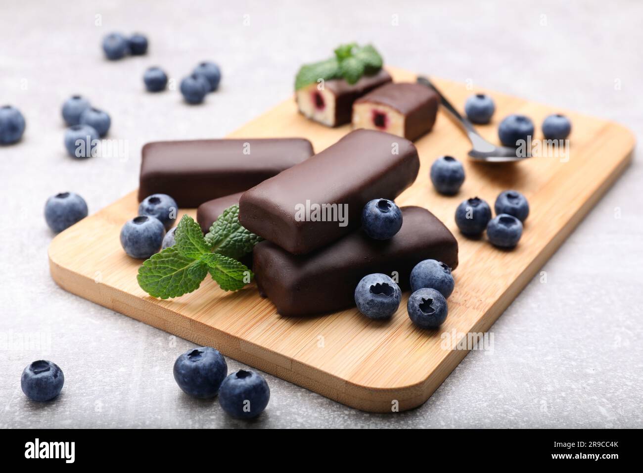 Delicious glazed curd snacks with fresh blueberries and mint on light ...
