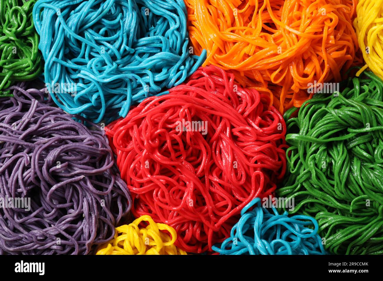 Rolled spaghetti painted with different food colorings as background ...