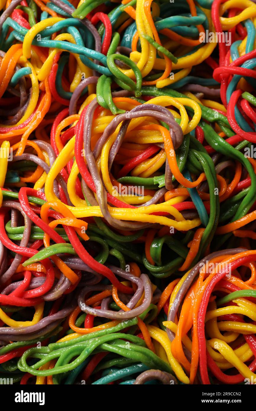 Spaghetti painted with different food colorings as background, top view ...