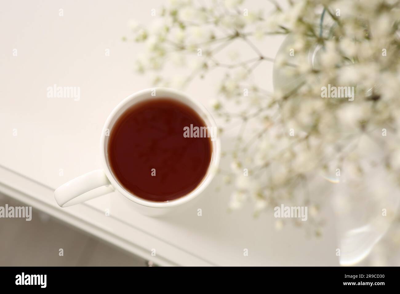 Ceramic mug with tea on white bedside table indoors, top view Stock ...