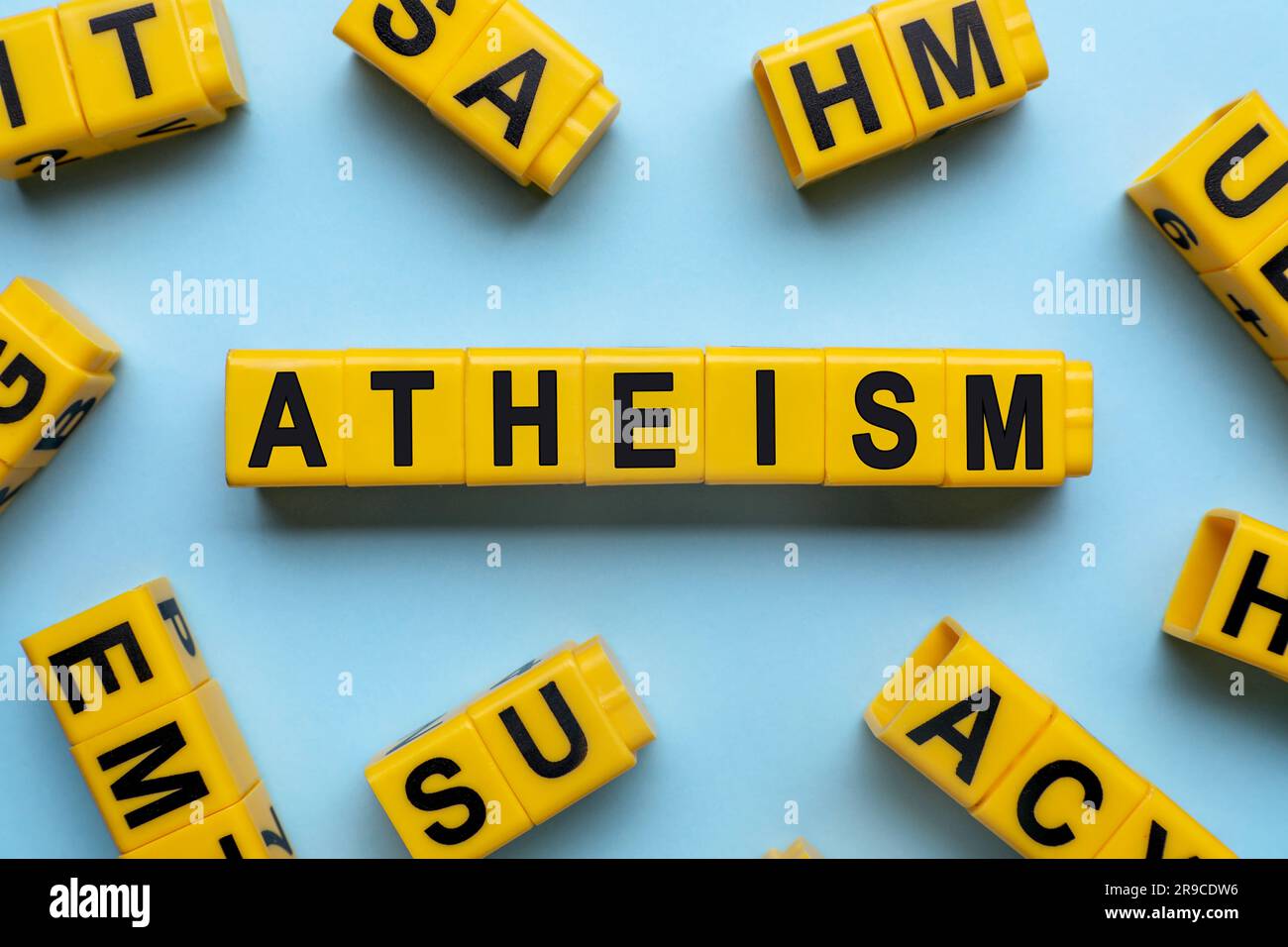Word Atheism made of yellow cubes with letters on light blue background ...