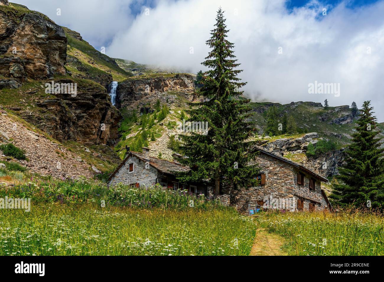 View of rural field, two stone houses and the mountain with small ...