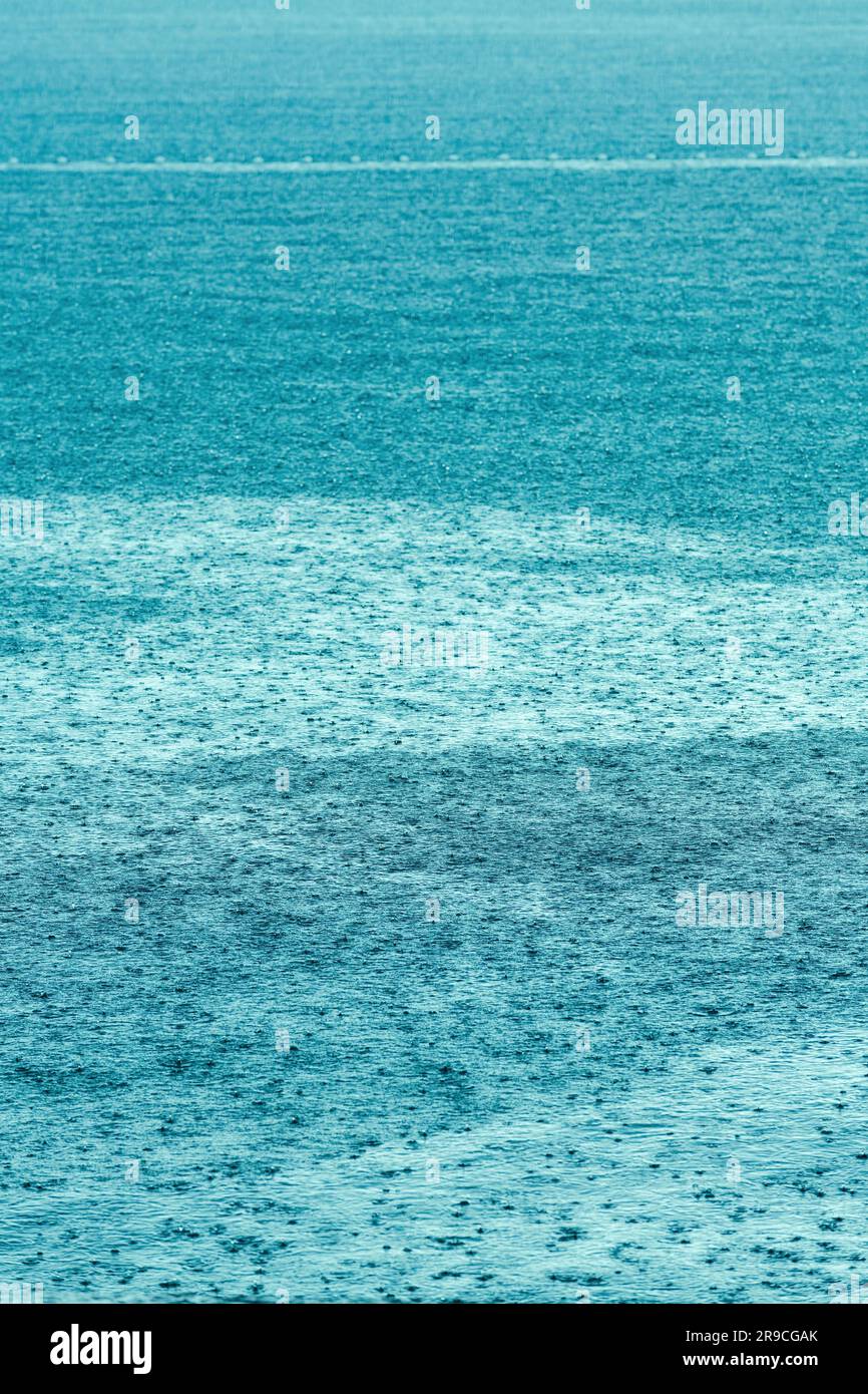 Sudden summer shower rain at seaside, raindrops forming patterns on ...