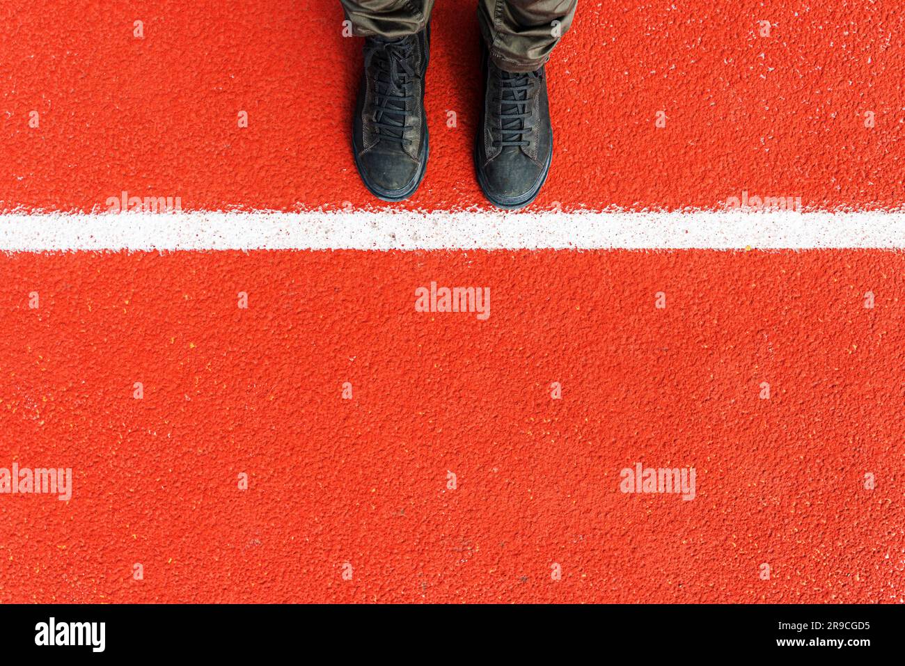 Top view of dirty male boots standing next to the white line, afraid ...