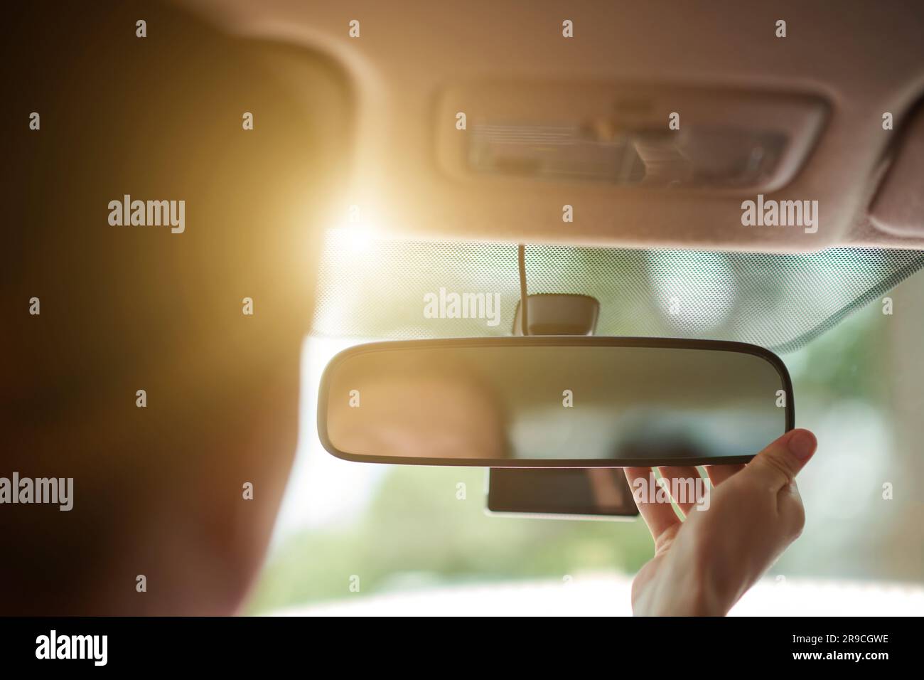 Driver fixing rearview mirror when driving car to work Stock Photo - Alamy