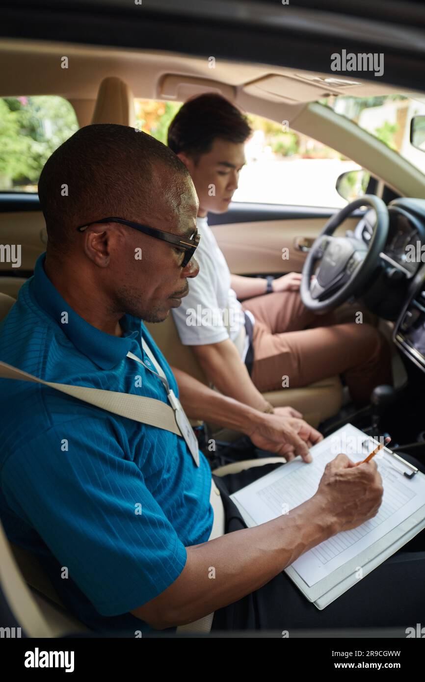 Instructor filling evaluation checklist when his student passing exam ...