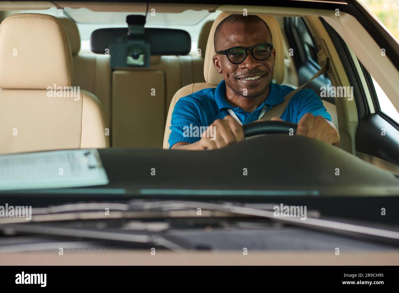 Happy but worried sweaty Black man driving car for the first time Stock ...