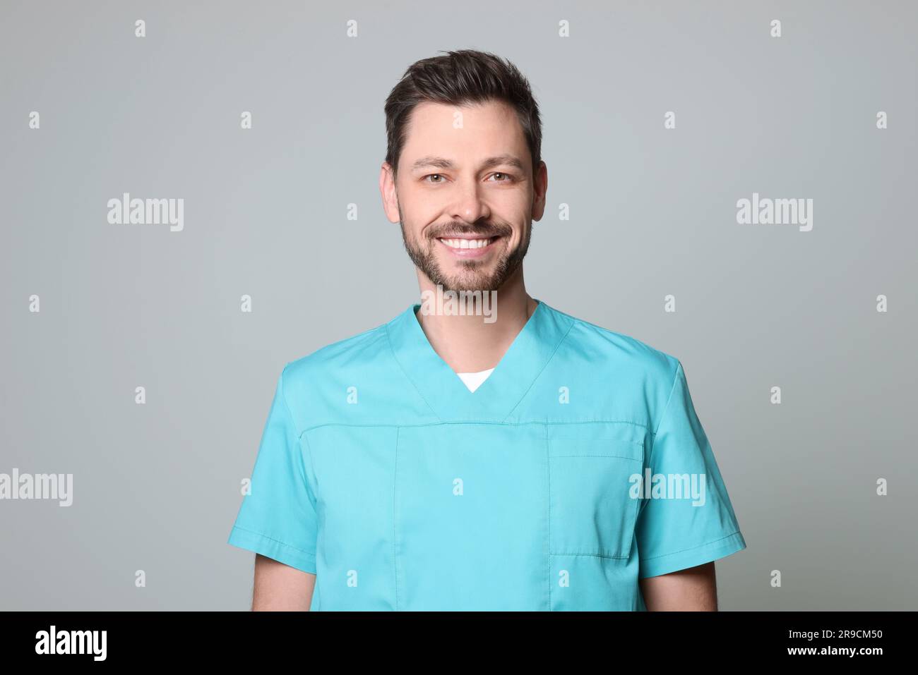 Doctor or medical assistant (male nurse) in uniform on light grey ...