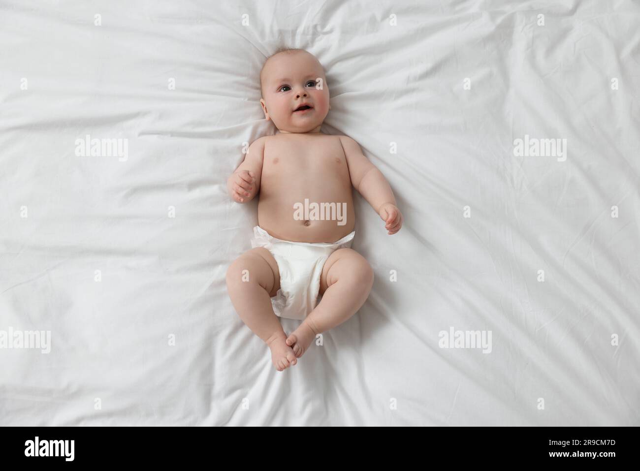 Cute little baby in diaper lying on white bed, top view Stock Photo - Alamy