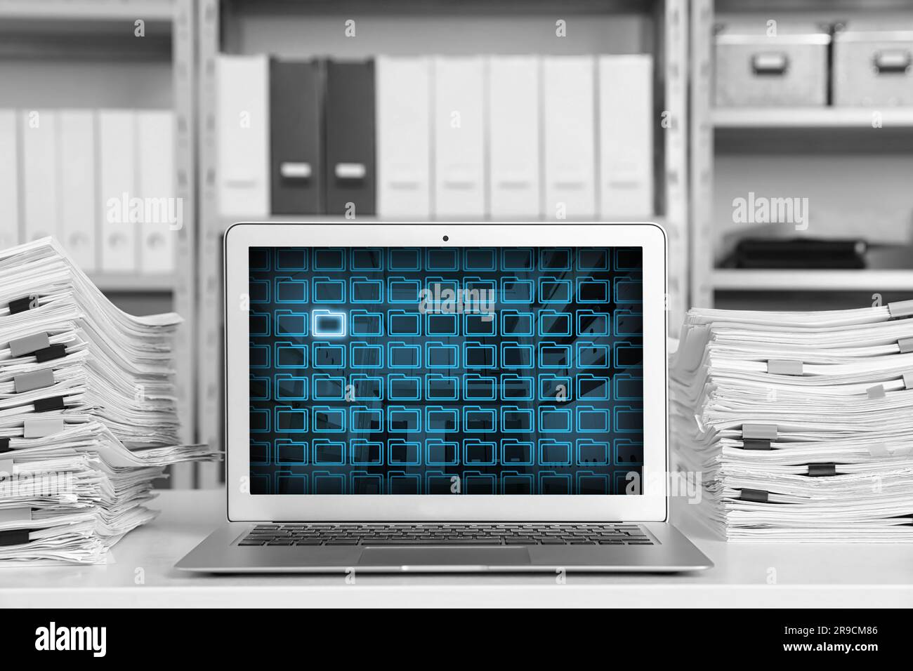 Laptop with digital archive program in office. Many folder icons and ...