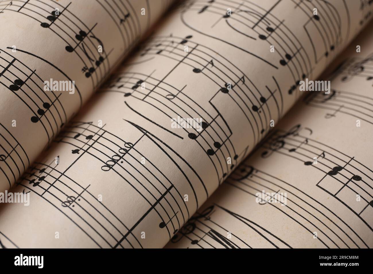 Rolled sheets with music notes as background, closeup Stock Photo - Alamy