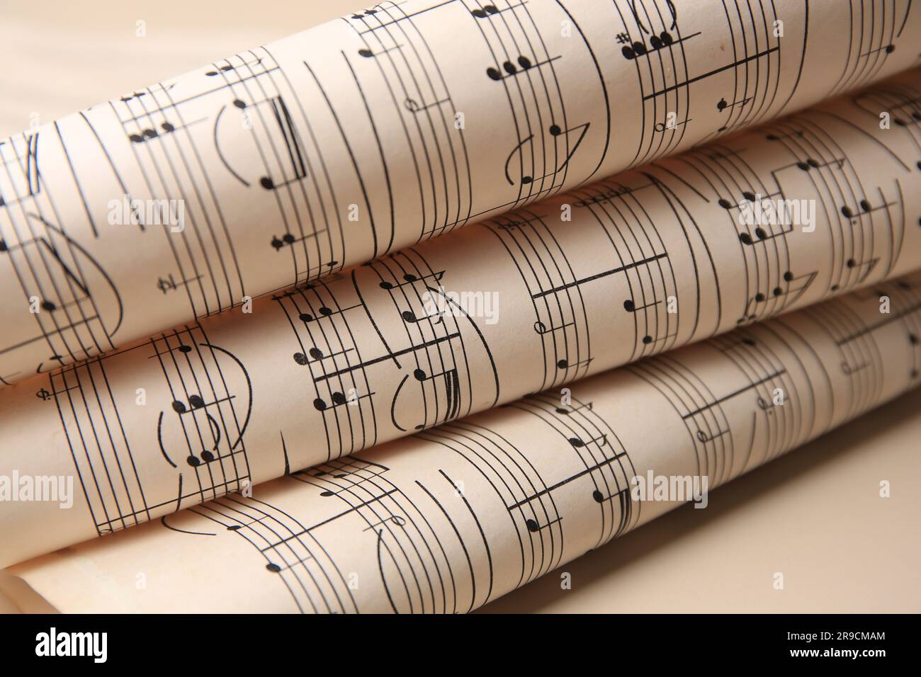 Rolled sheets with music notes on light background, closeup Stock Photo ...