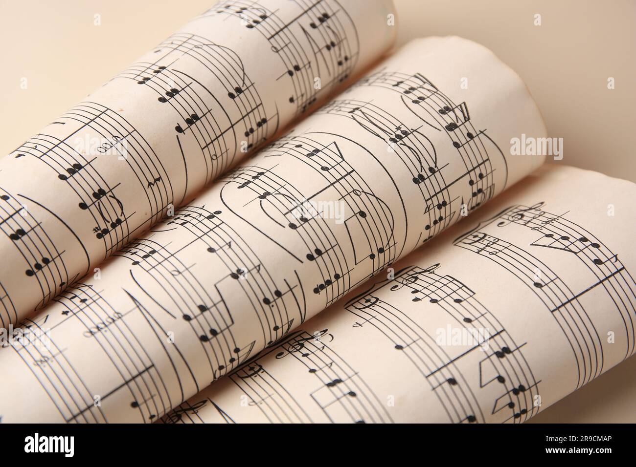Rolled sheets with music notes on light background, closeup Stock Photo ...