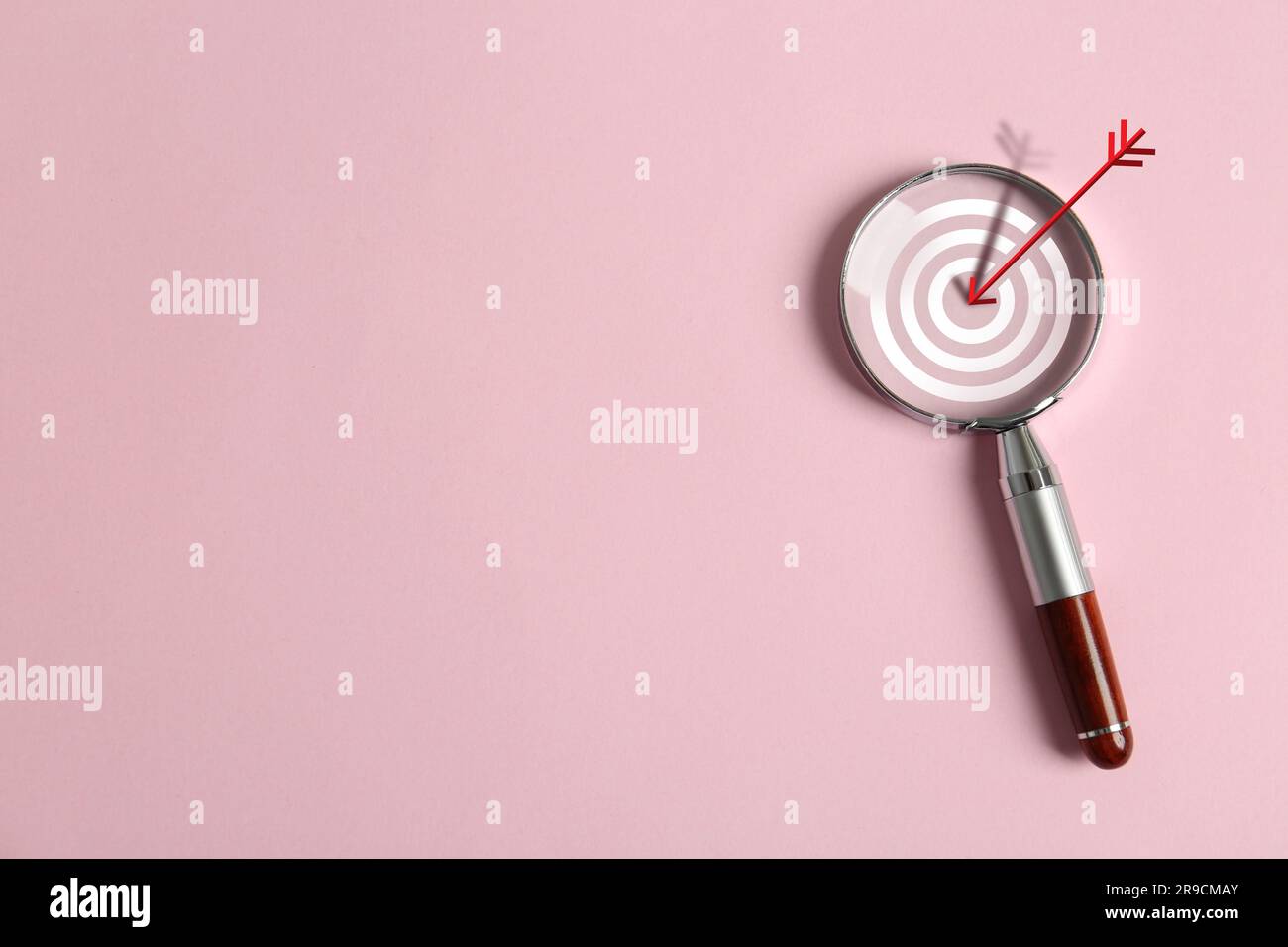 Magnifying glass with illustration of target and arrow on pink ...