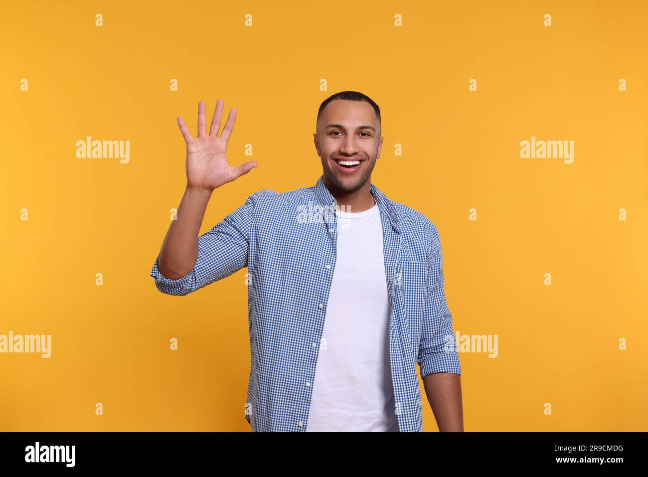 Man giving high five on yellow background Stock Photo - Alamy