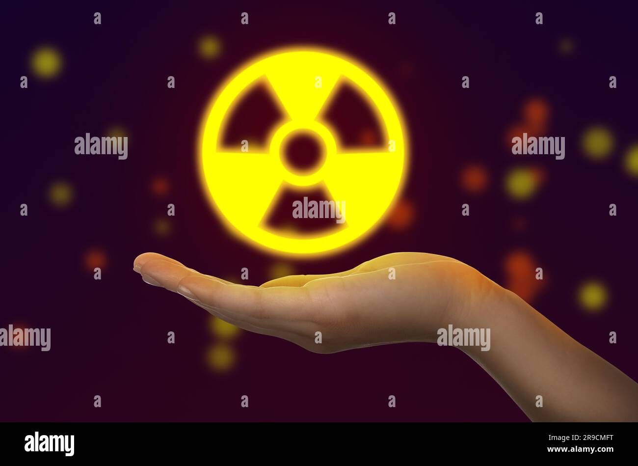 Woman holding glowing radiation warning symbol on dark background ...