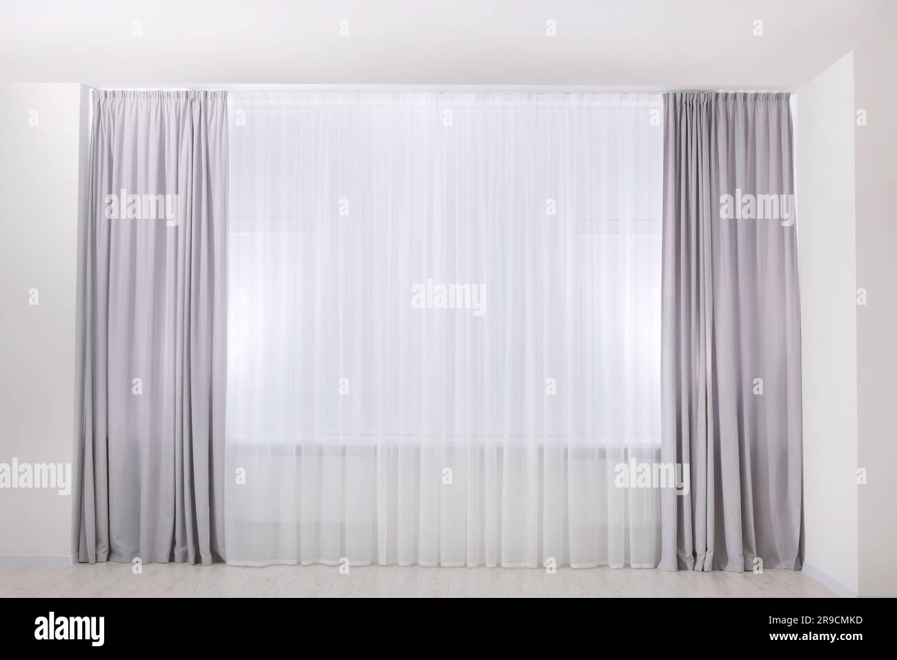 Light grey window curtains and white tulle indoors Stock Photo - Alamy