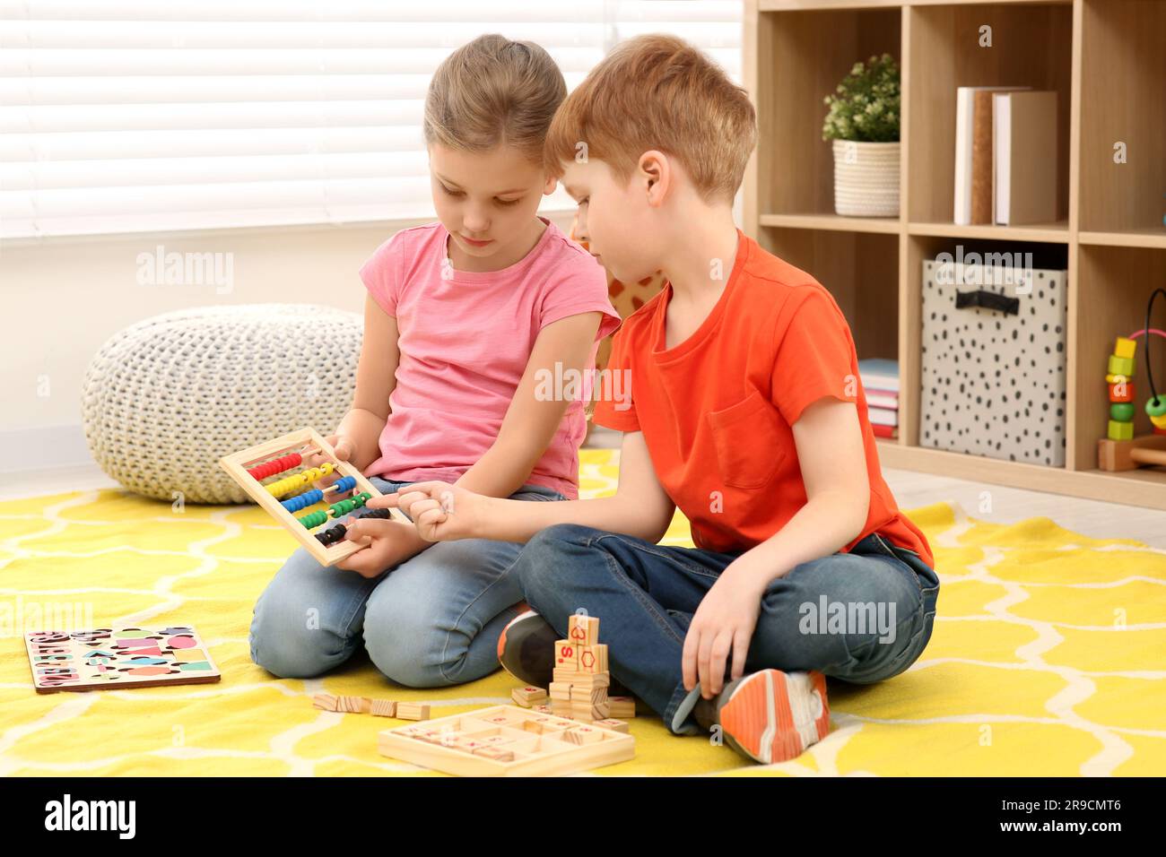 Children playing with abacus on floor in room. Learning mathematics ...