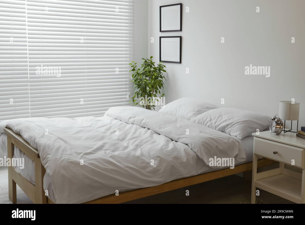 Stylish room with comfortable bed and bedside table at night. Interior ...