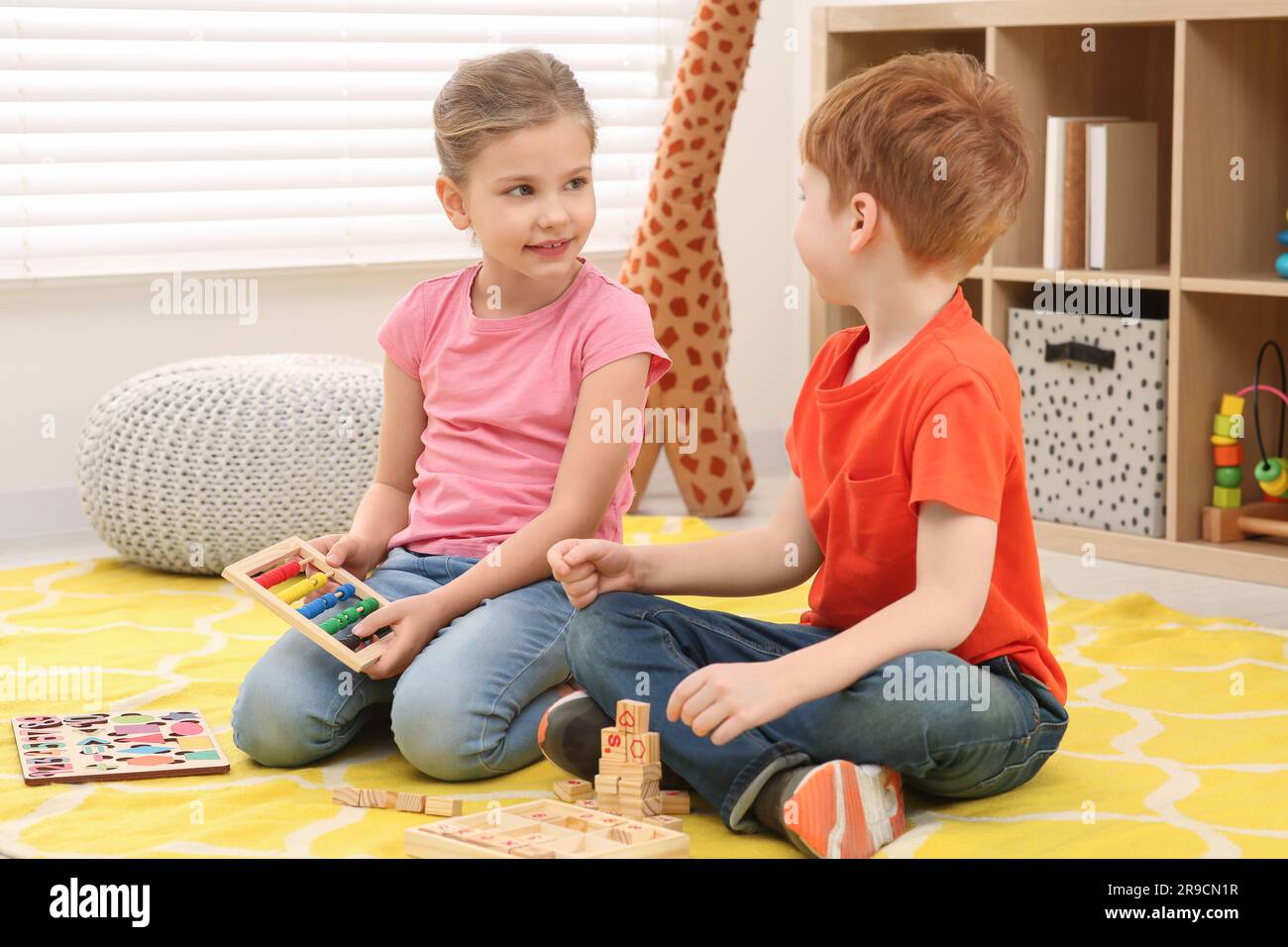 Children playing with abacus on floor in room. Learning mathematics ...