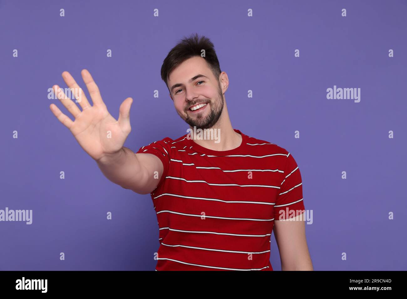 Man giving high five on purple background Stock Photo - Alamy