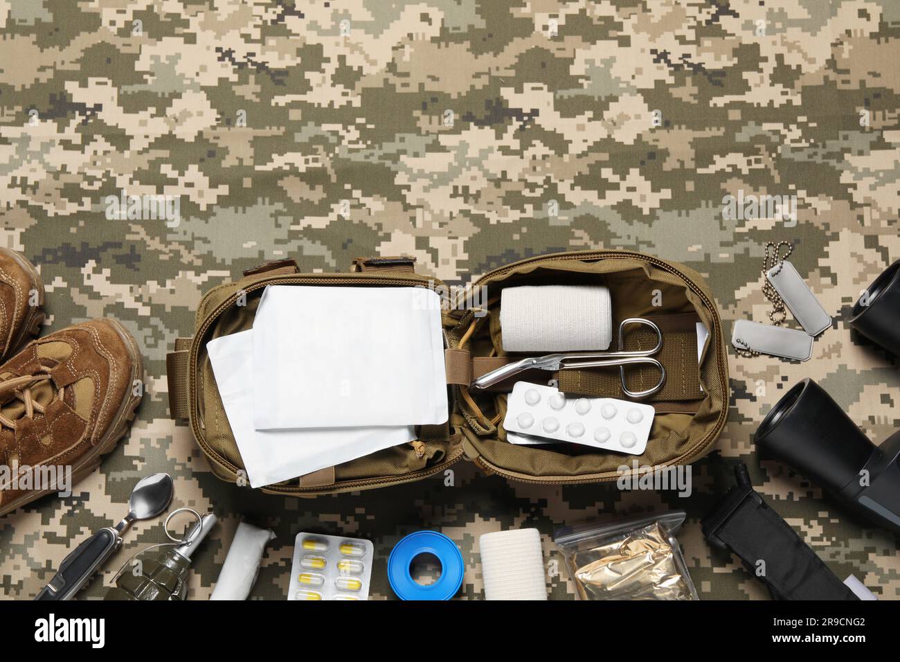 Flat lay composition with military first aid kit on camouflage fabric ...