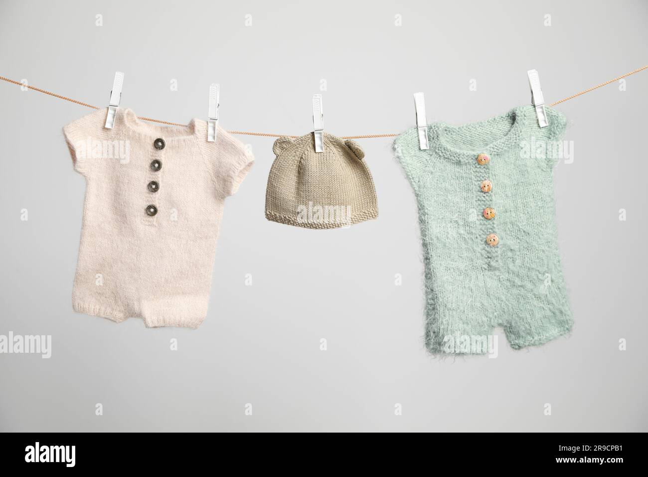 Baby clothes drying on washing line against white background Stock ...