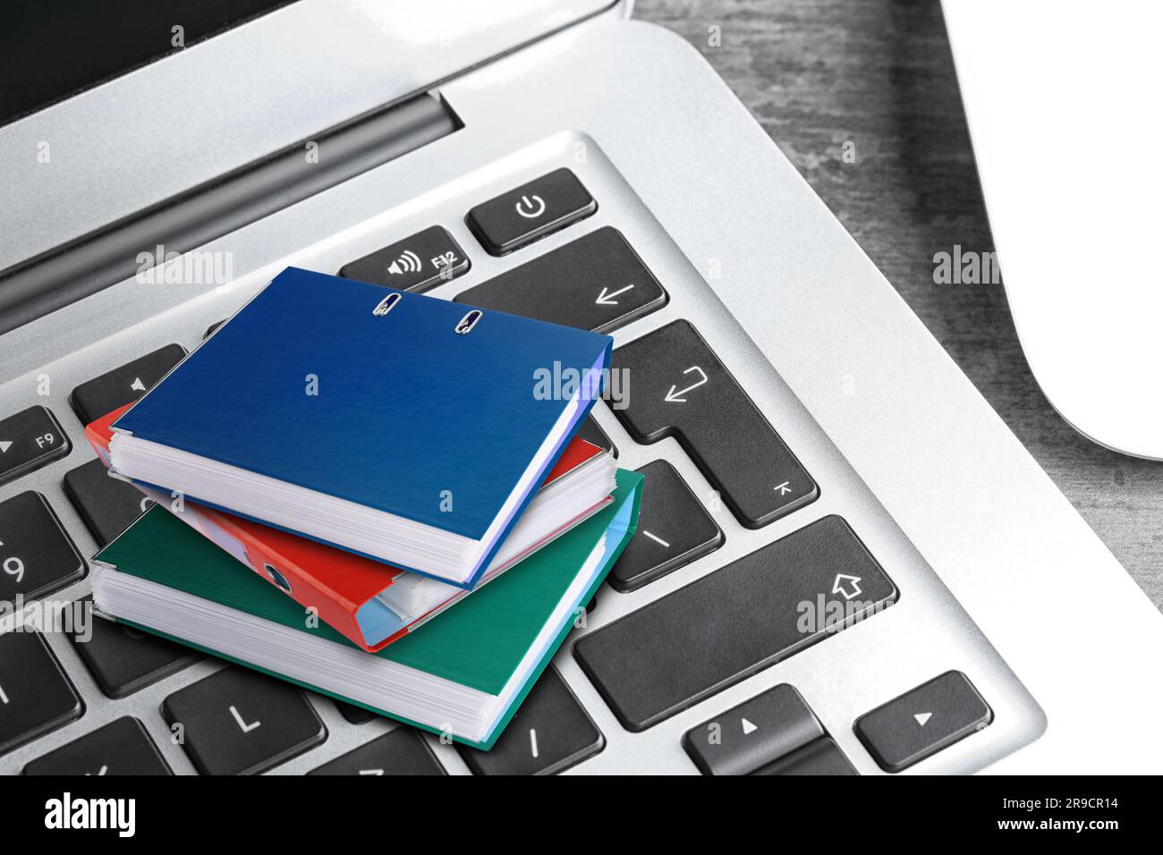 Digital archive. Laptop keyboard with stacked downsized folders on ...
