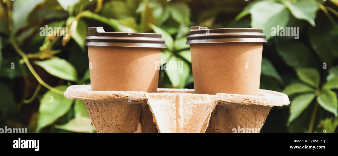 Two takeaway paper coffee cups cardboard holder in outdoors. Banner ...